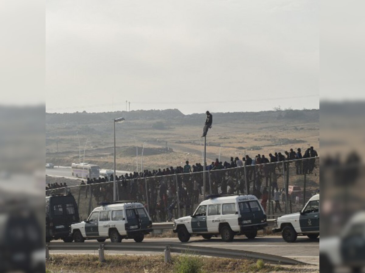 Hundreds of migrants storm across Spanish border in North African enclave