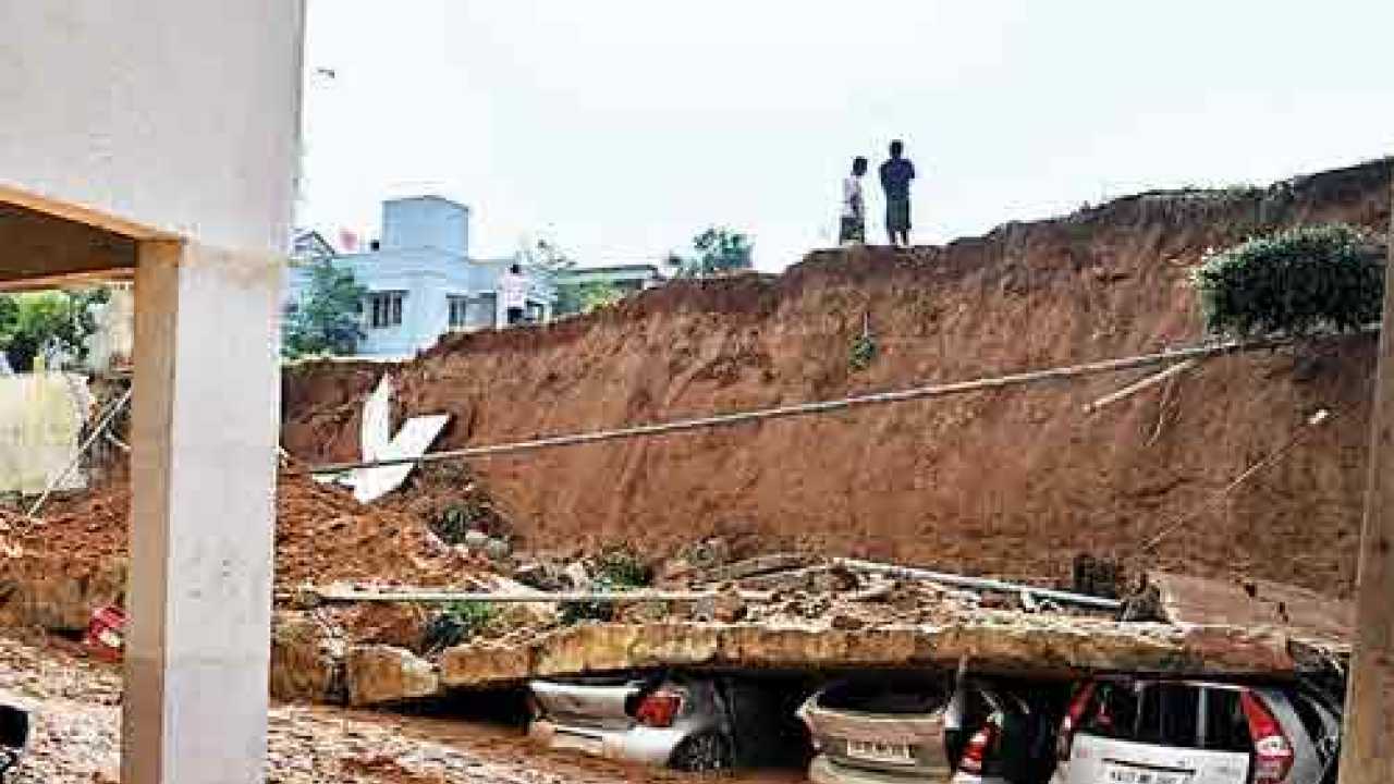 Apartment compound wall crashes; crushes cars