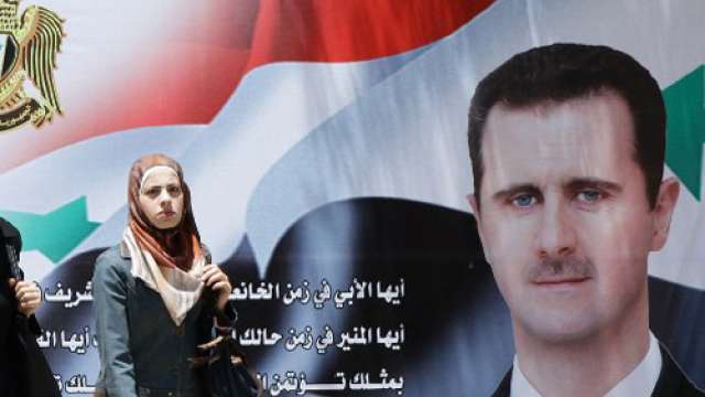 Election posters of Syria's President Bashar al-Assad hang above a road ...